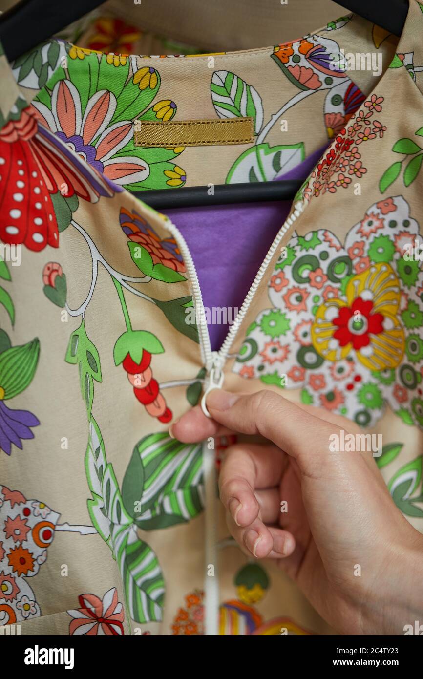 Woman's hands unzipping floral blouse. woman hand holding up zipper ...