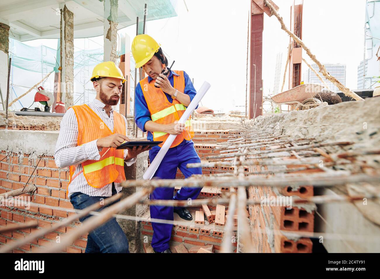 Serious contractors walking up the stairs in building under ...