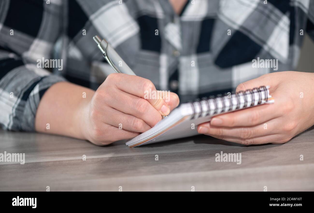 Female hands taking notes on notepad Stock Photo - Alamy