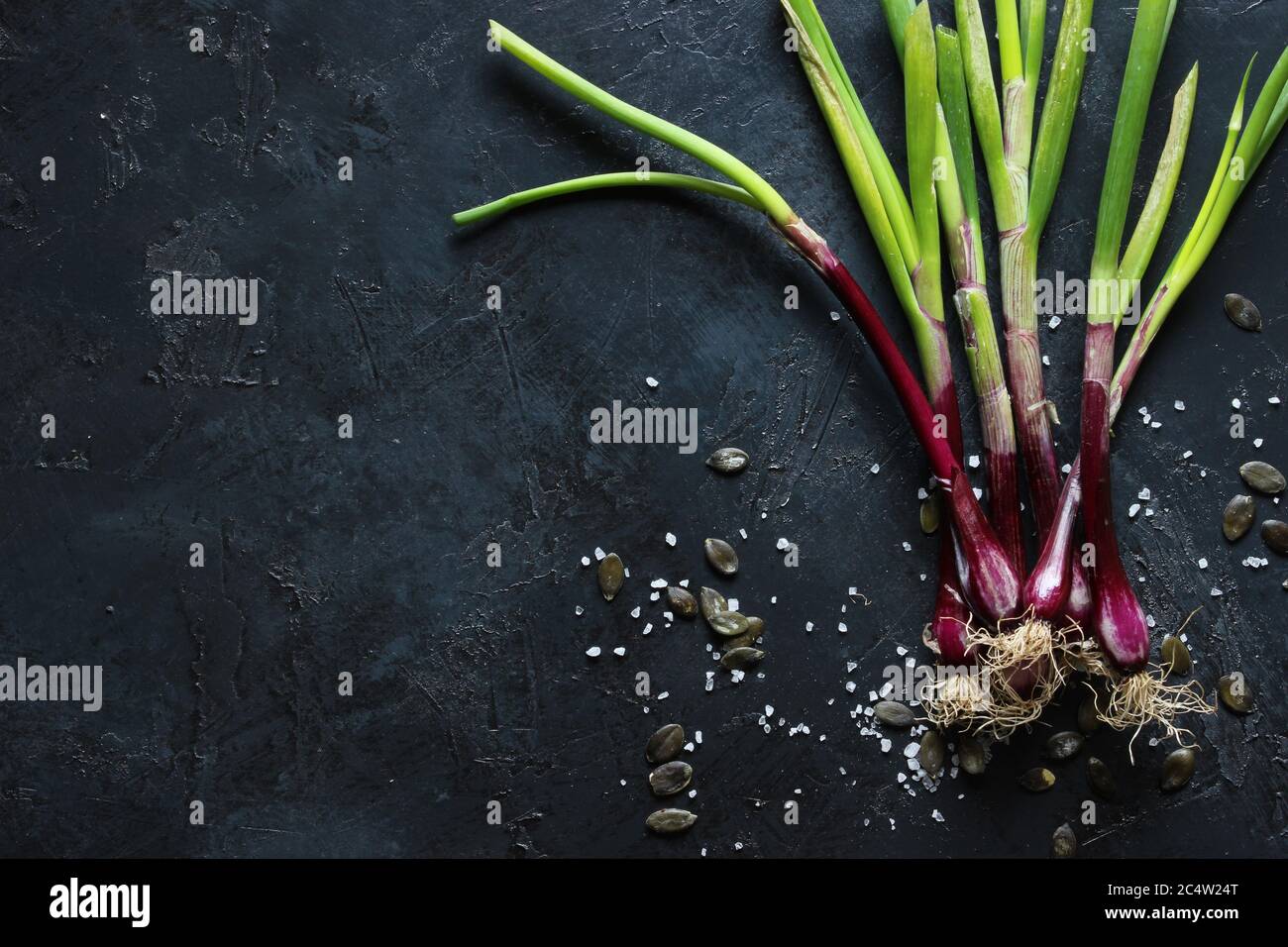 purple spring onions on dark table background Stock Photo - Alamy