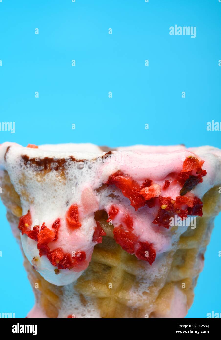 vanilla and strawberry flavor ice cream cone in a melting process close ...