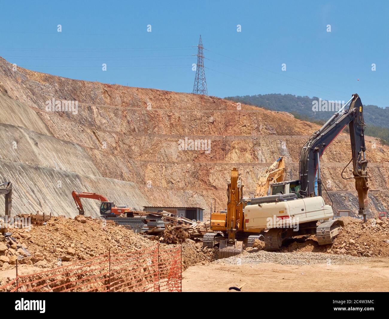 Excavator and hydrohammer during quarrying on the rocky soils. Heavy ...