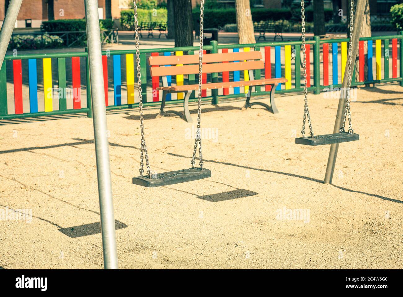 children's playground with empty swings suspended with steel chains ...