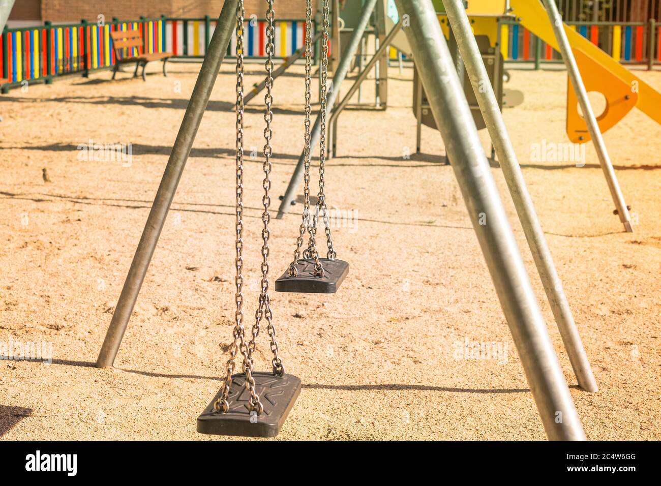 children's playground with empty swings suspended with steel chains ...