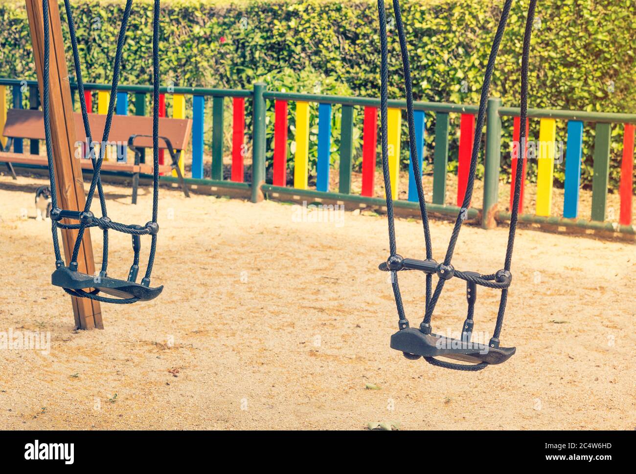children's playground with empty swings suspended with steel chains ...
