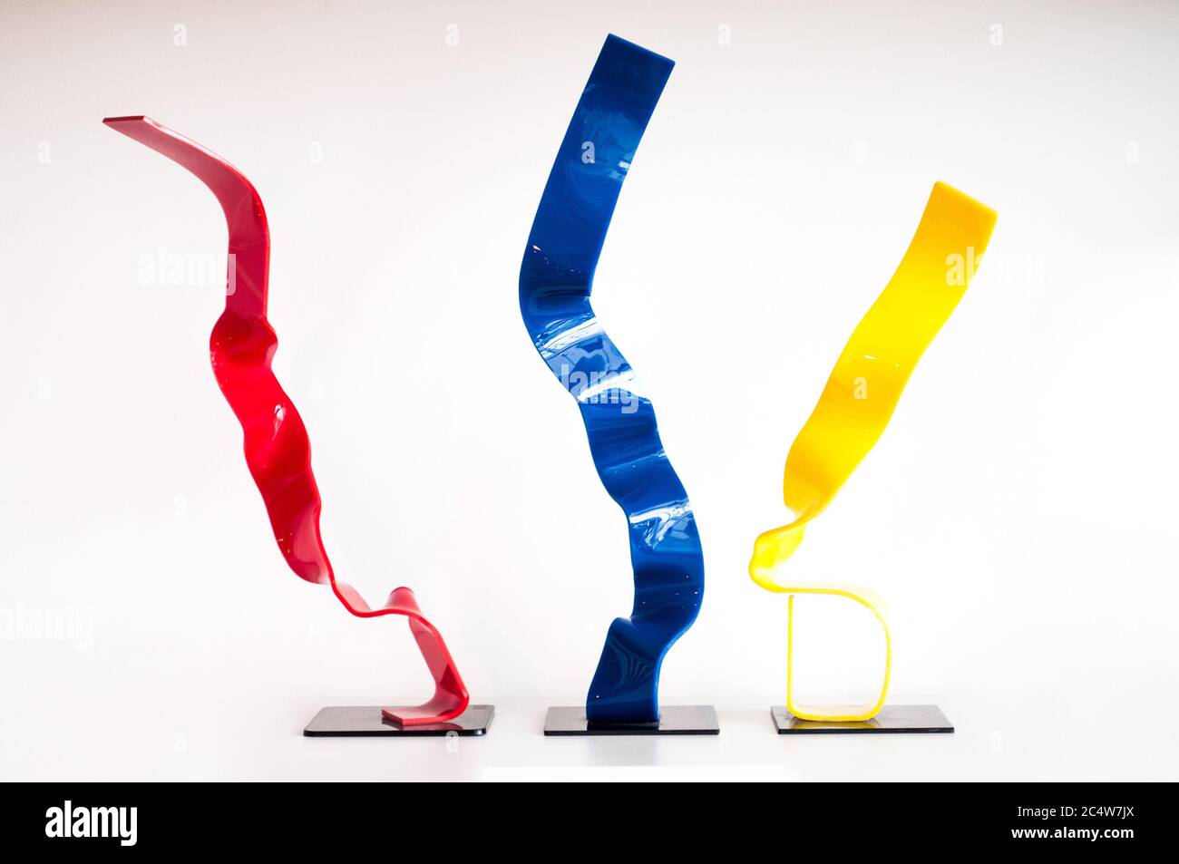 Red, blue and yellow ribbons flying in the air with a white background ...