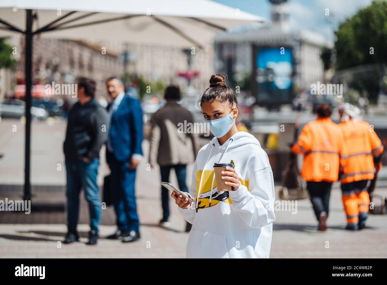 Young woman holding coffee wearing protective medical mask Stock Photo ...