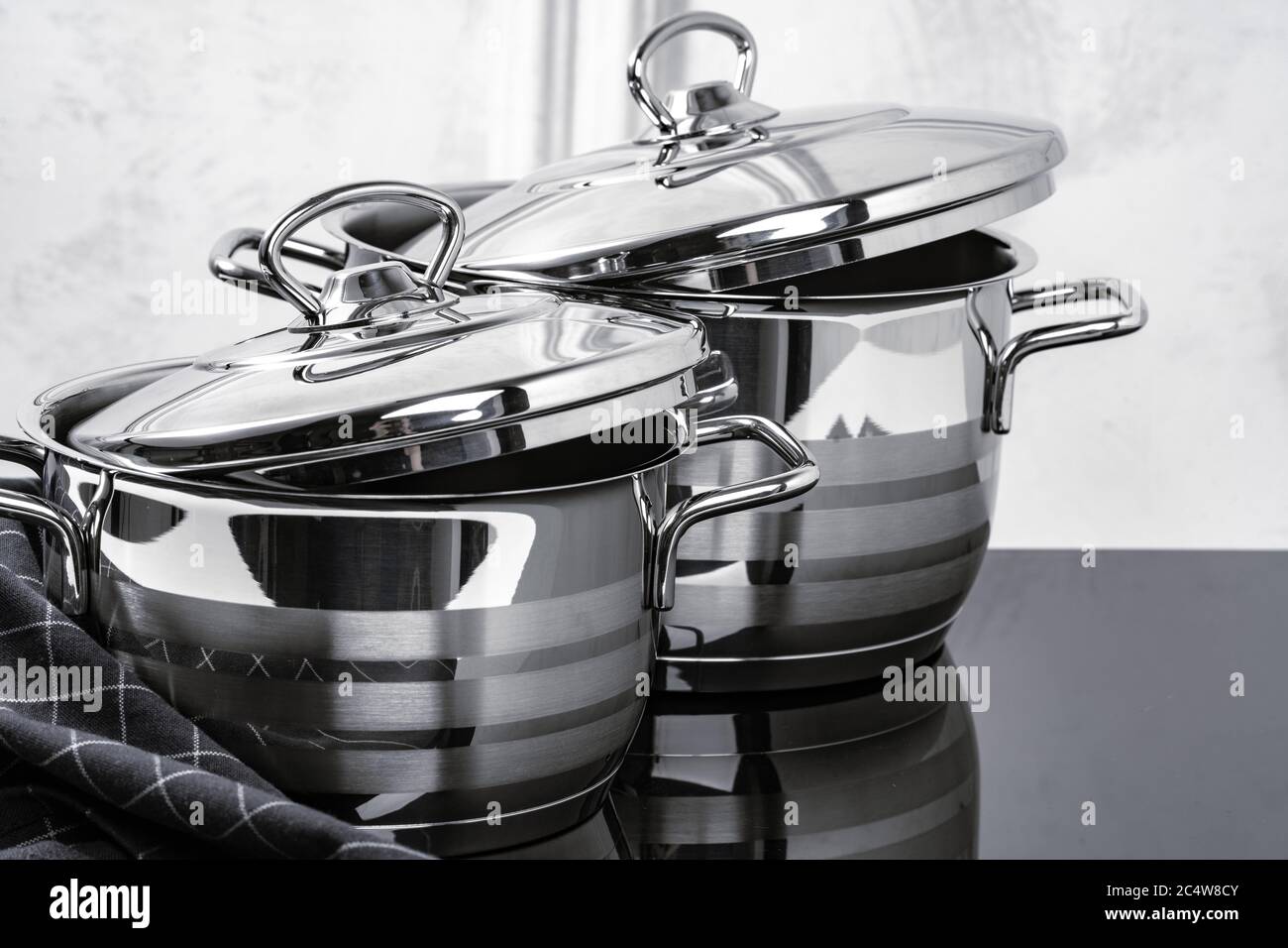 Aluminum cookware on black induction stove against grey wall Stock ...