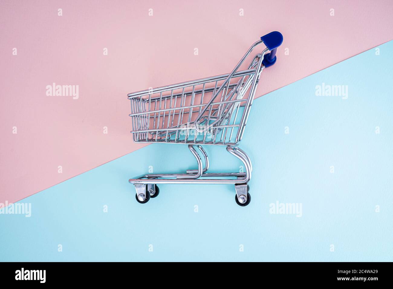 empty shopping cart over colour background, mini metal cart isolated on ...