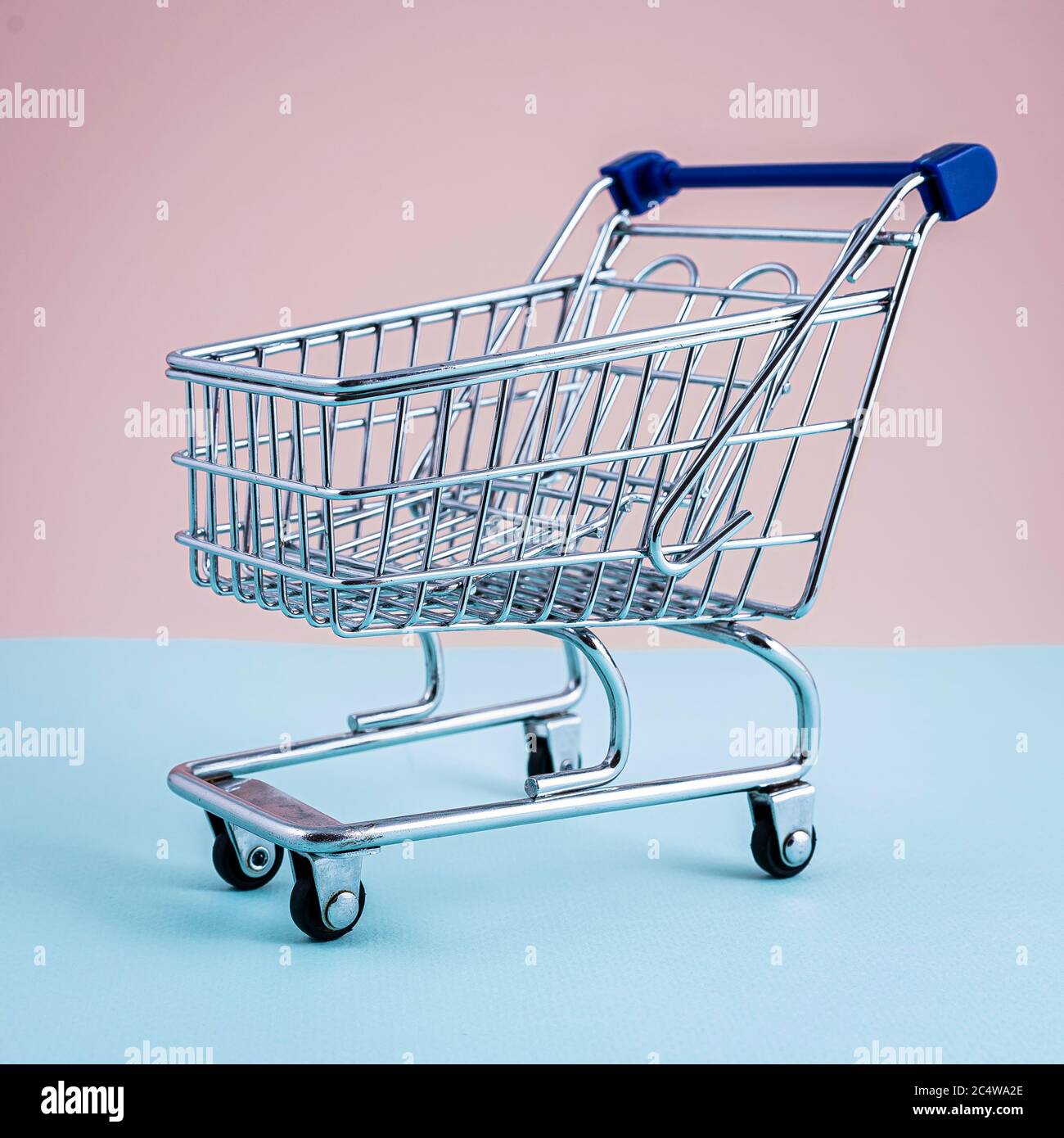 empty shopping cart over colour background, mini metal cart isolated on ...