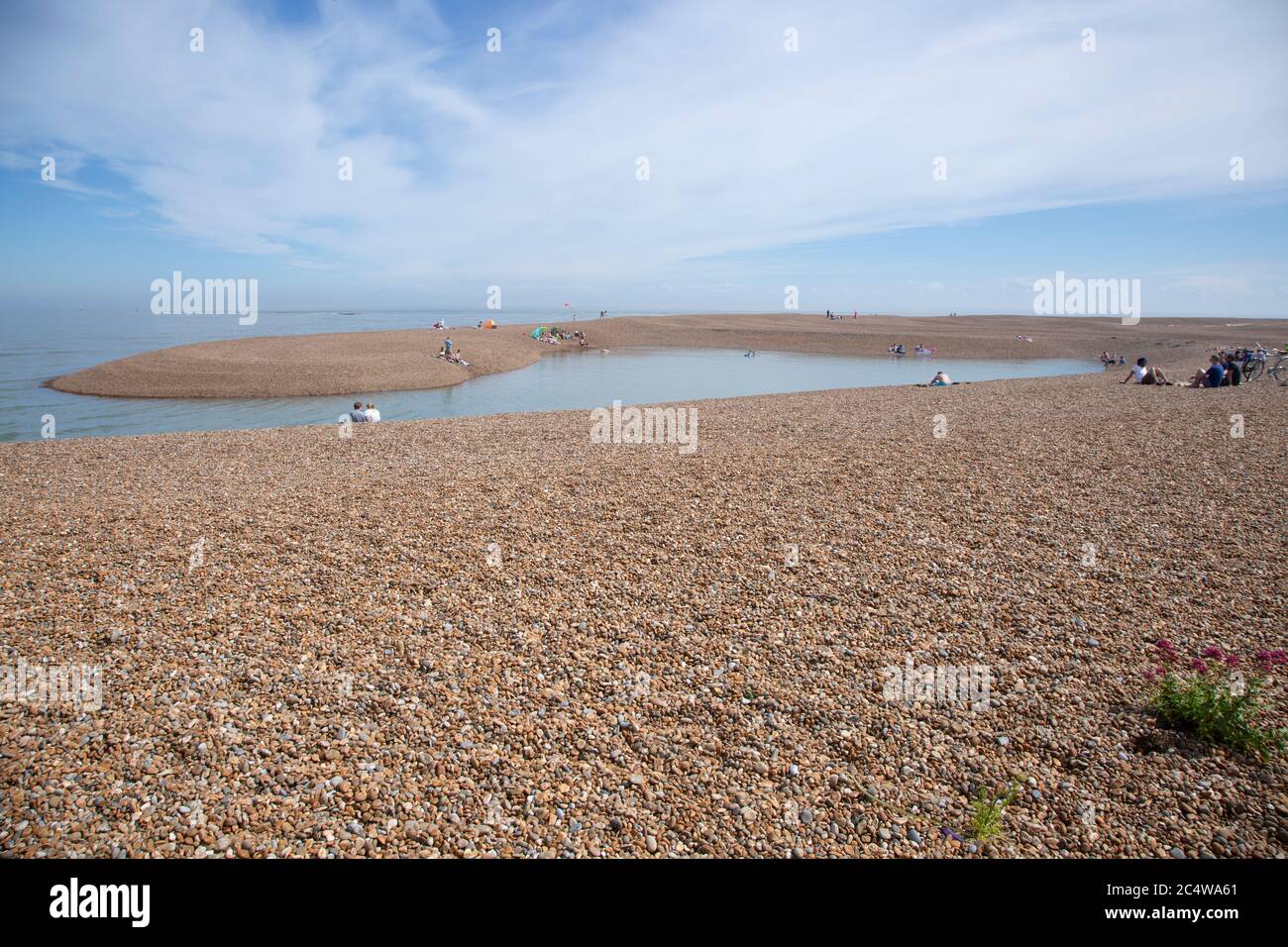 People enjoying a clam day sitting around a recently formed lagoon on ...