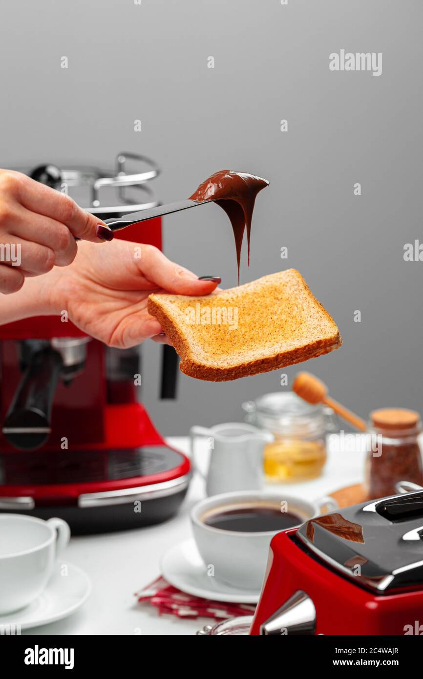 Female hand cooking toast with chocolate paste Stock Photo - Alamy