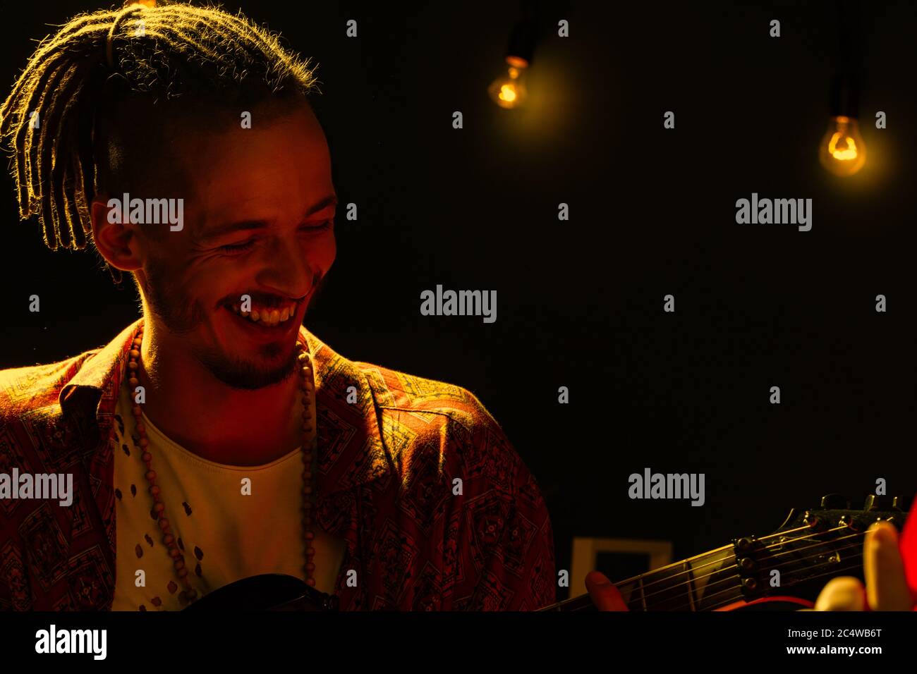 Young caucasian man musician playing guitar in the dark Stock Photo - Alamy