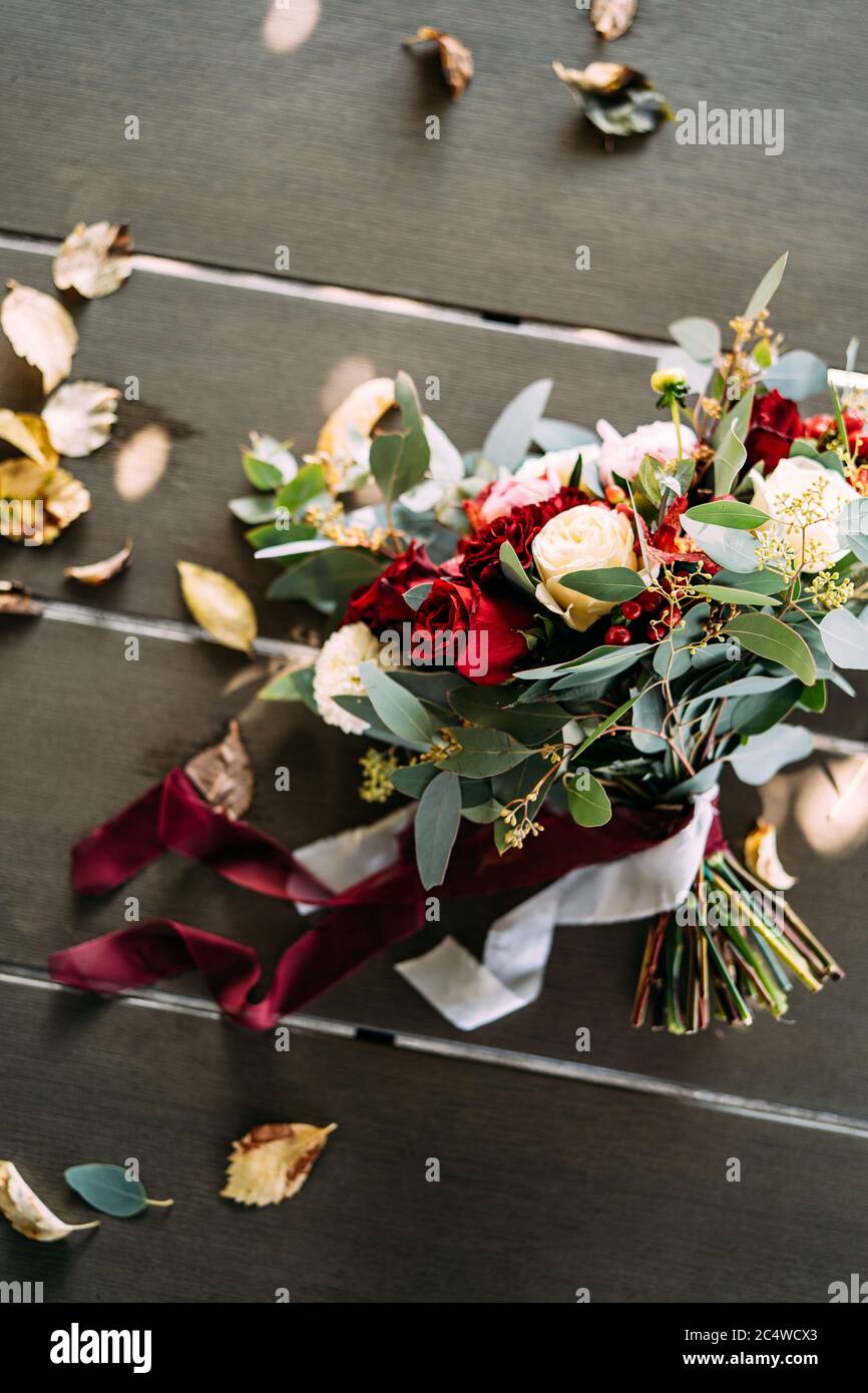 bridal bouquet of white and red roses, peonies, branches of eucalypt ...