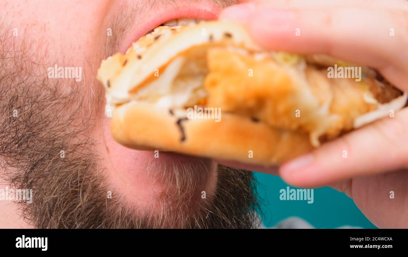 Close up of a man biting a burger on a Chroma Key. The concept of ...