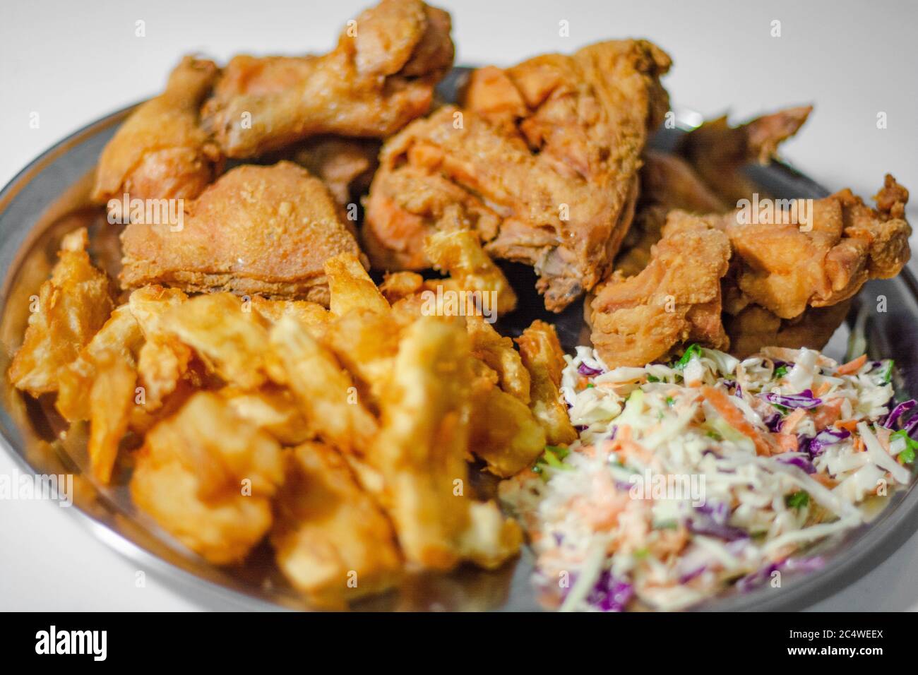 Crispy fried chicken served with potatoes and vegetable salad Stock ...
