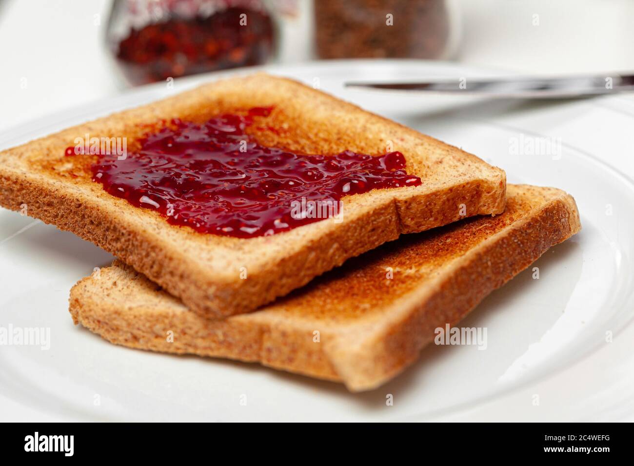 Crispy toasts covered with fruit jam served on kitchen table Stock ...