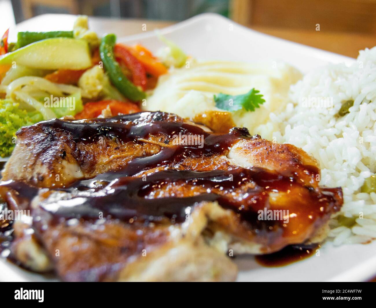 Roasted meat served with mashed potato, rice, and vegetable salad Stock ...