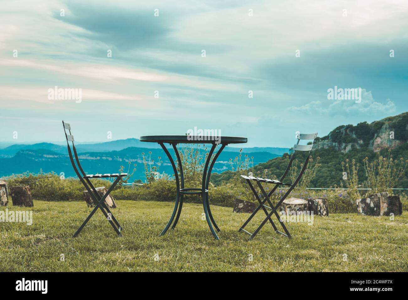 Two chairs facing each other and a table in the middle of nature ...