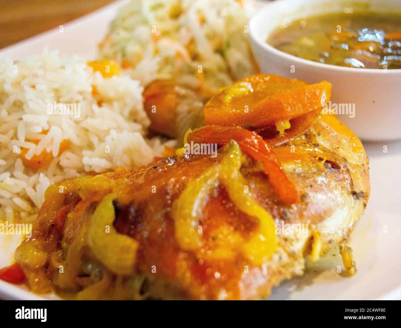 Chicken served with rice, vegetable salad, and a bowl of soup Stock ...