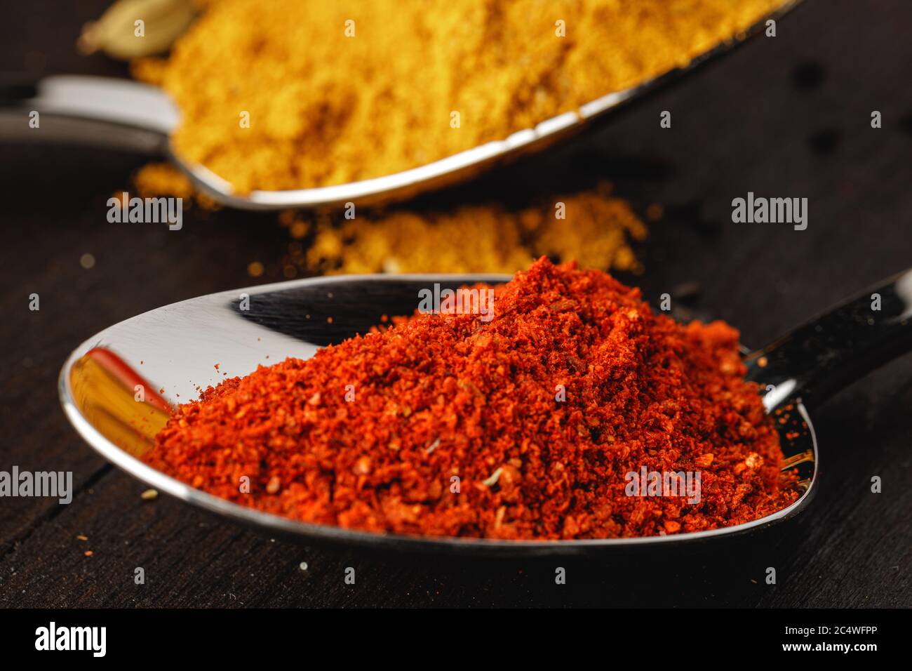 Spoon with spices on dark wooden table close up Stock Photo - Alamy