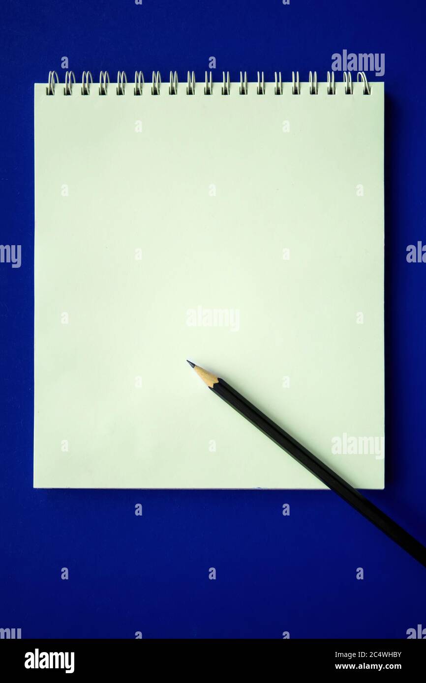 School notebook and pencil on blue background, back to school concept ...