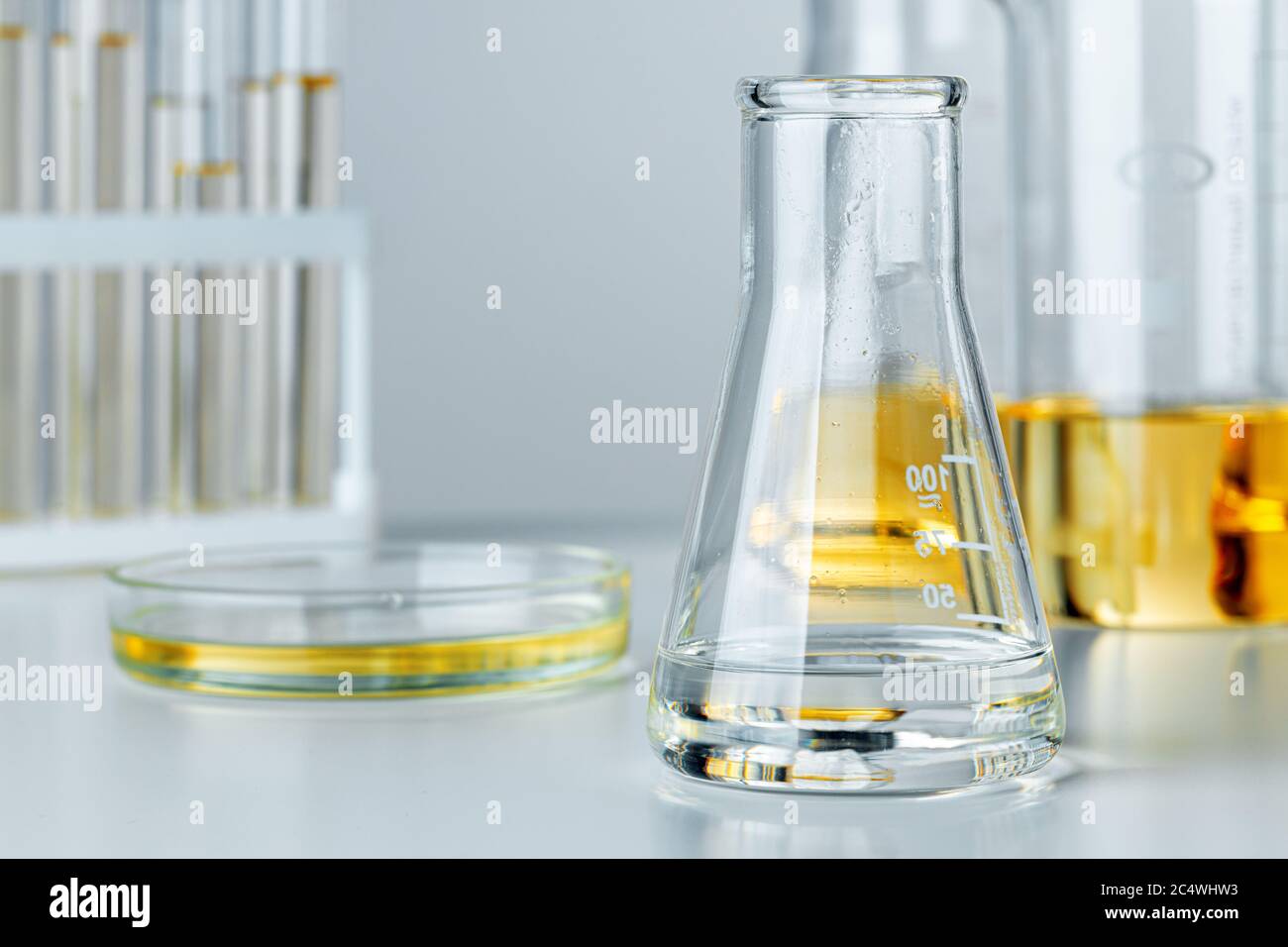 Laboratory glassware with yellow oily liquid on grey background Stock ...