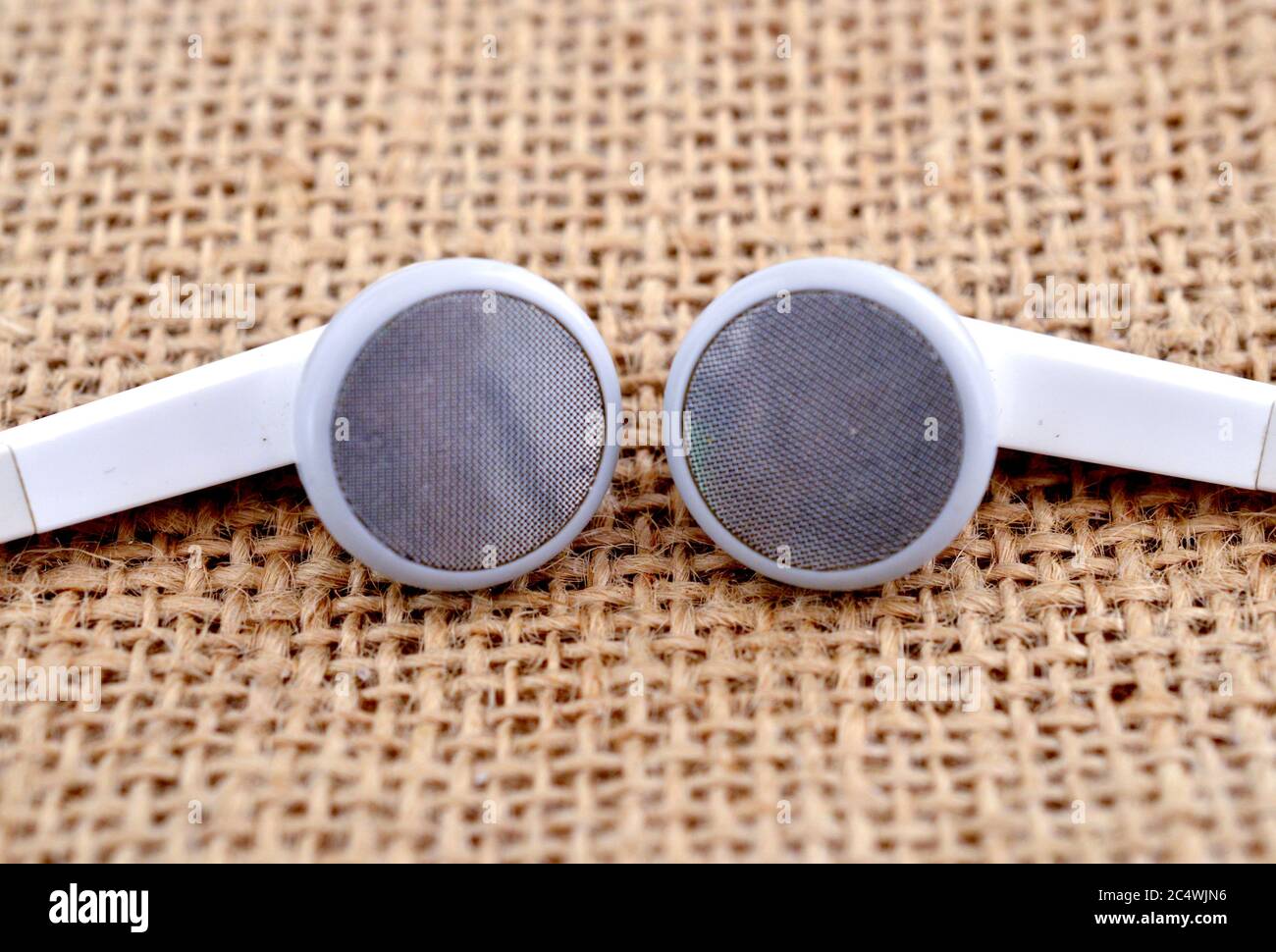 white used earbuds on jute bag background Stock Photo - Alamy