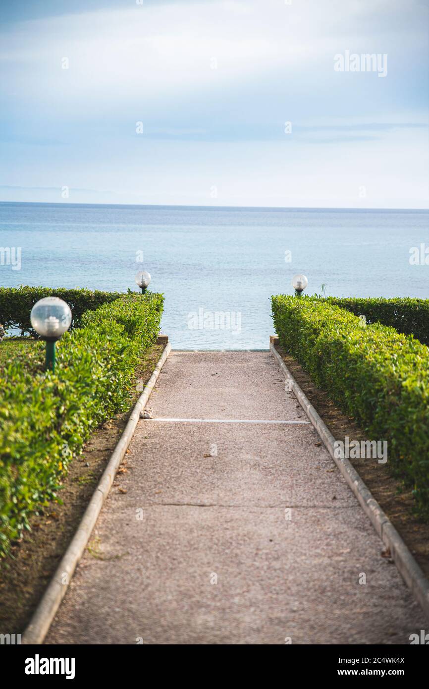 Small rock path with bushes left and right in front of the beach in ...