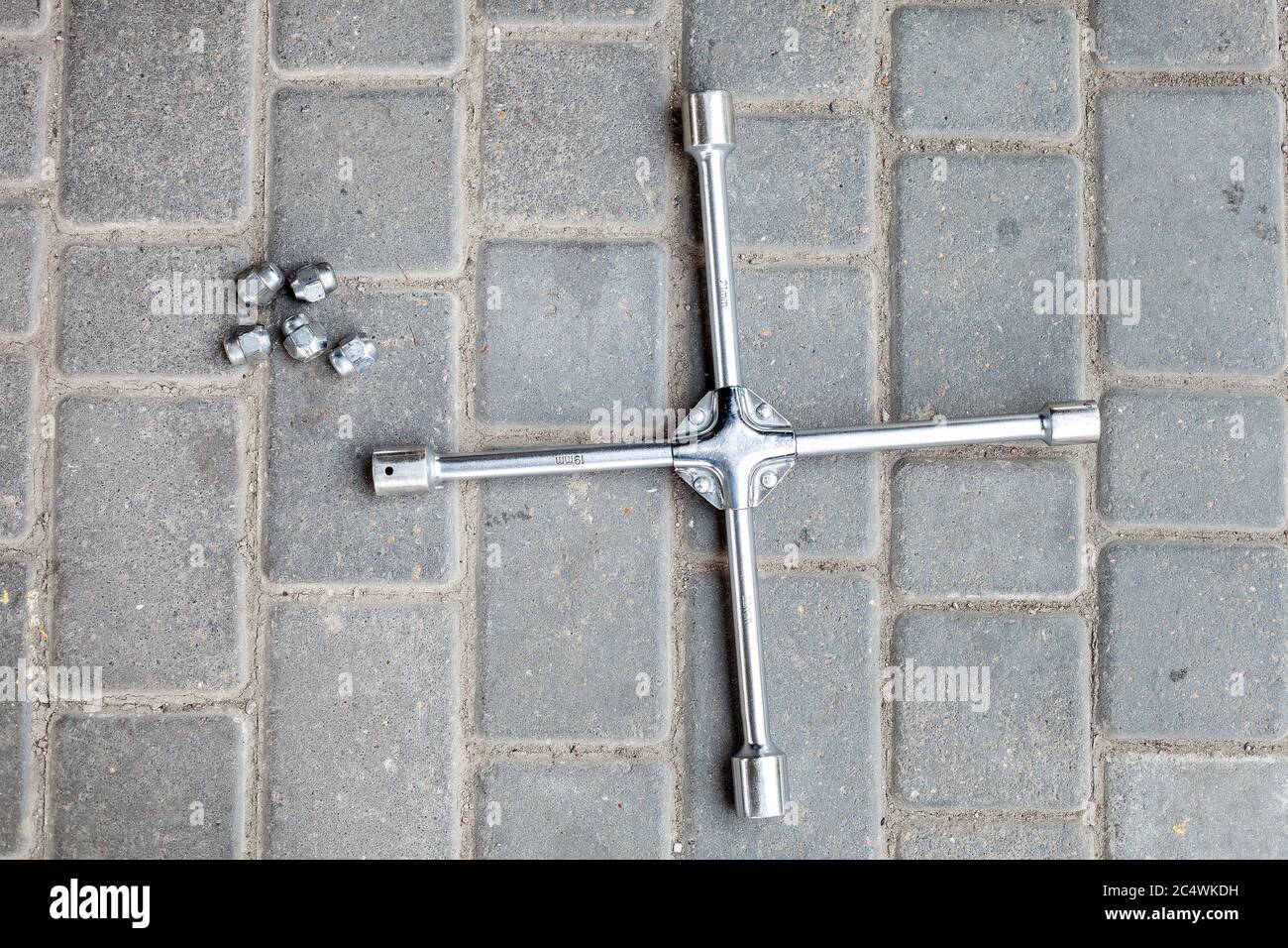 a cross wrench with different sizes of heads for loosening wheel nuts ...