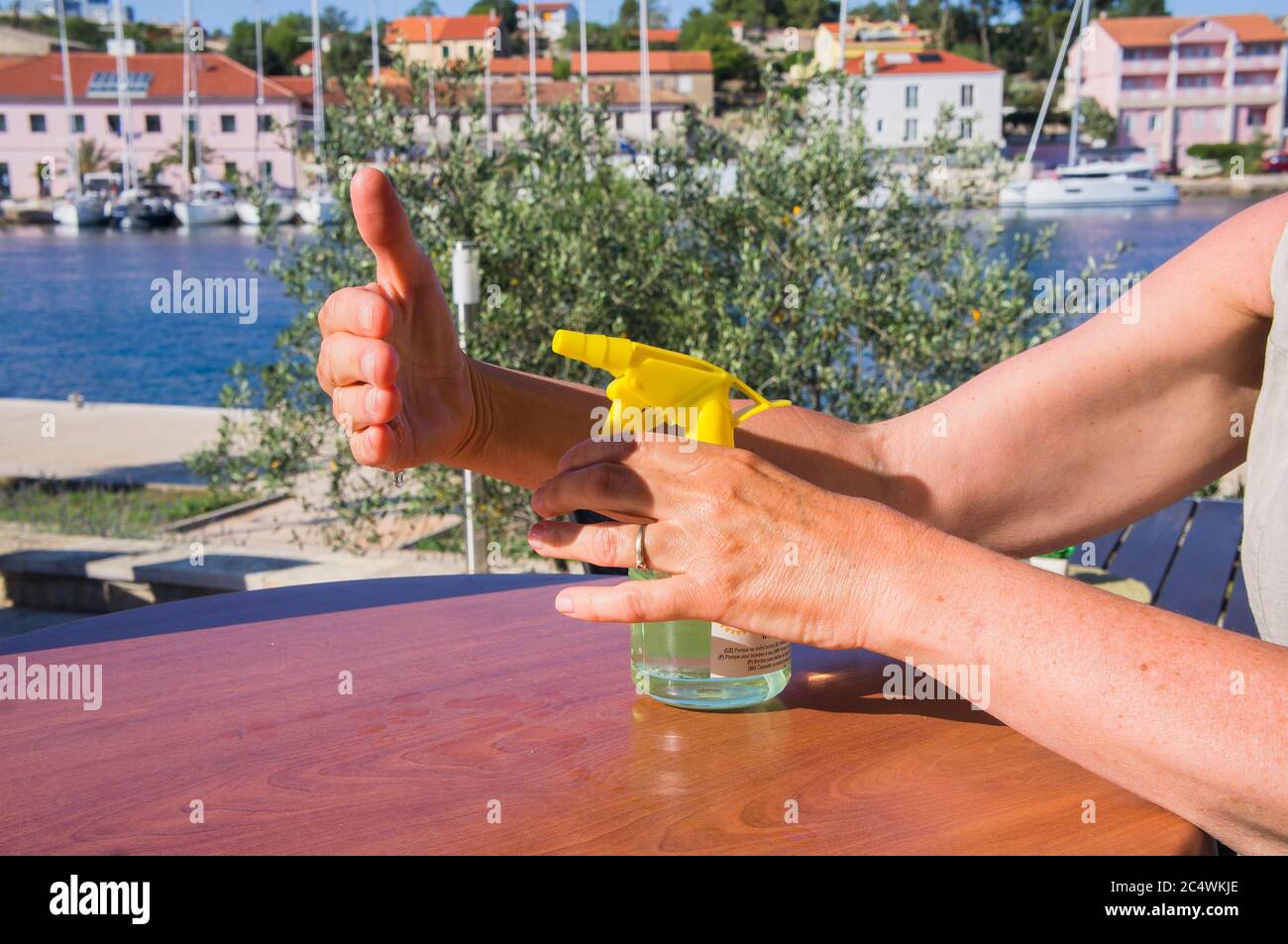 Illustrative photo, a woman uses a hand disinfection, sprayer ...