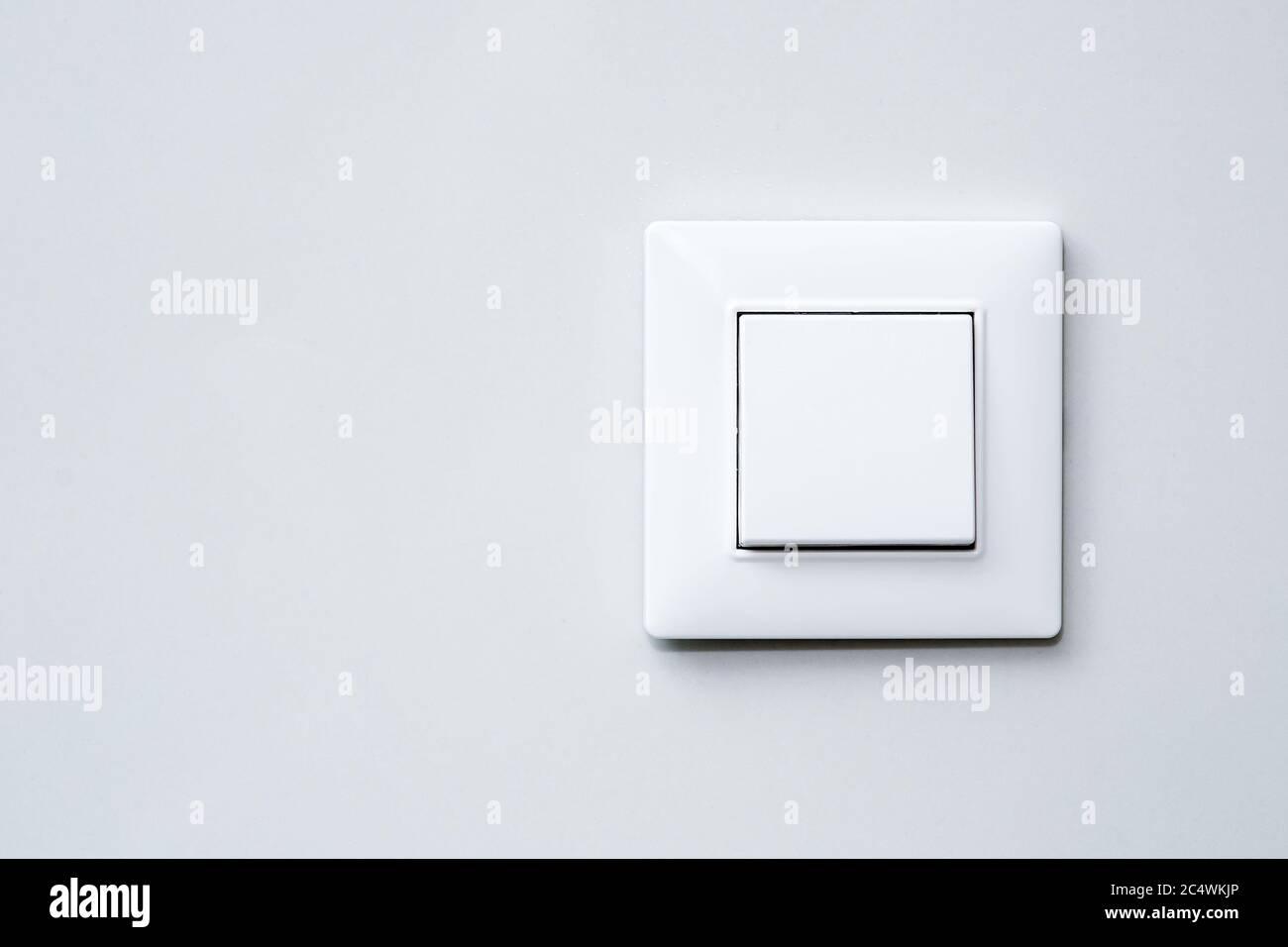 a light switch, a plastic mechanical switch of white color installed on ...
