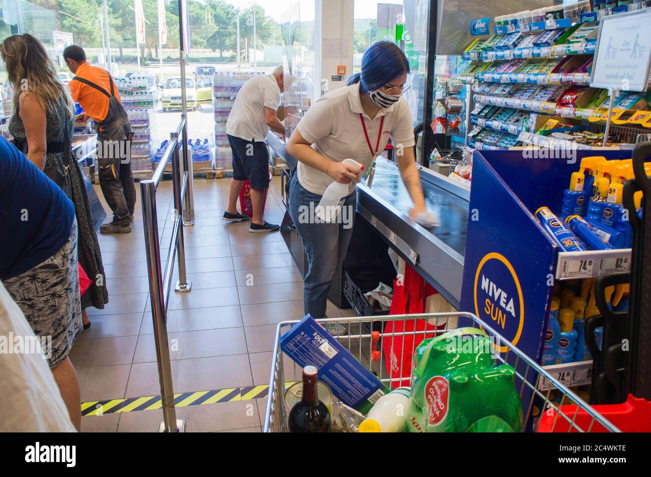 Spar shop cash desk, cashier wearing a face mask, a hand disinfection ...