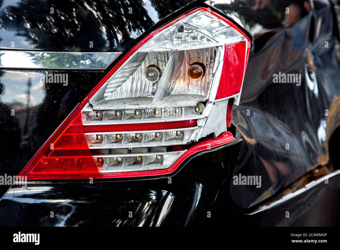 A rear lamp damaged in the incident and a fender of a car, a close-up ...