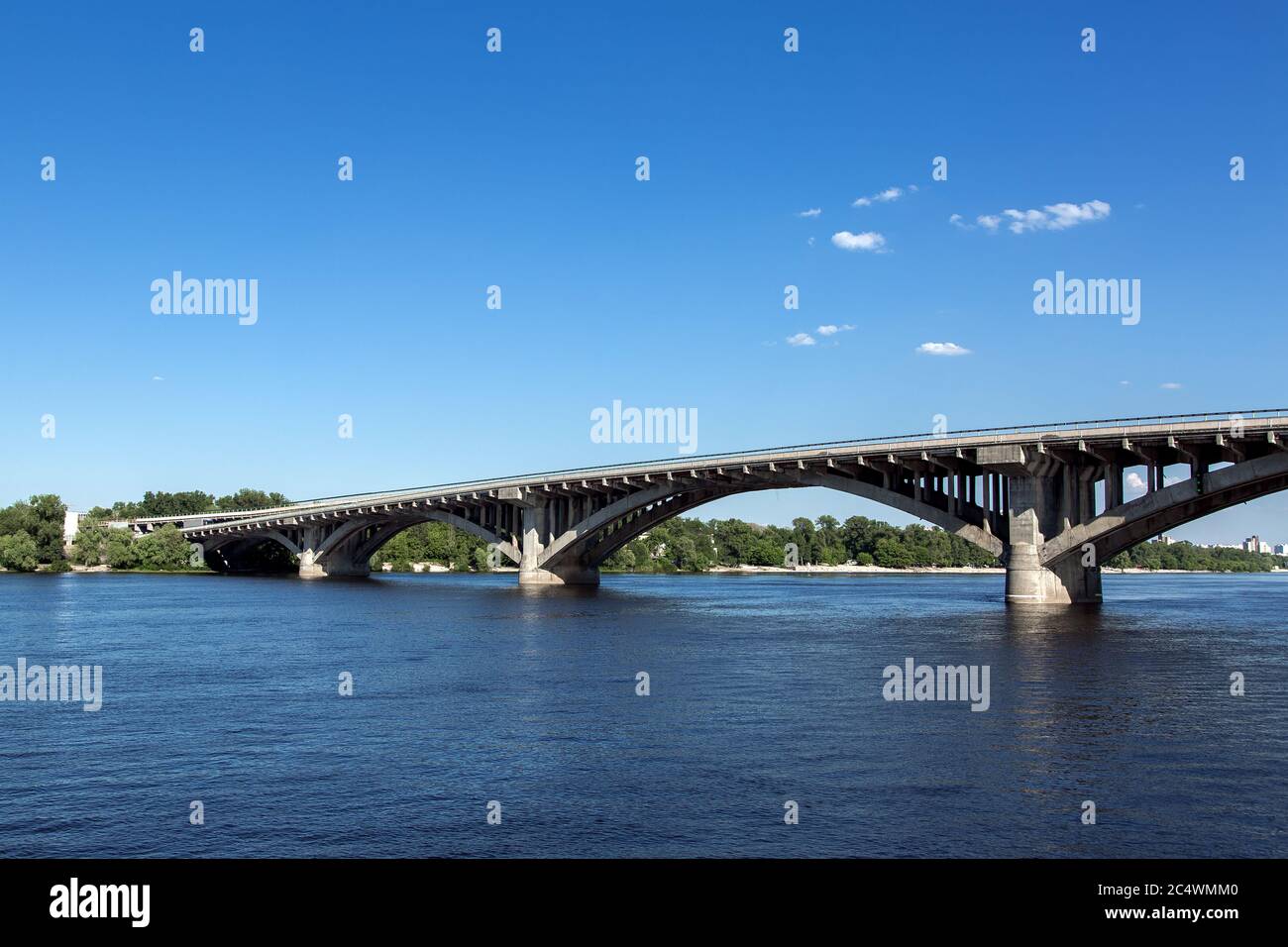 Concrete bridge arch structure across the river against the sky, bottom ...