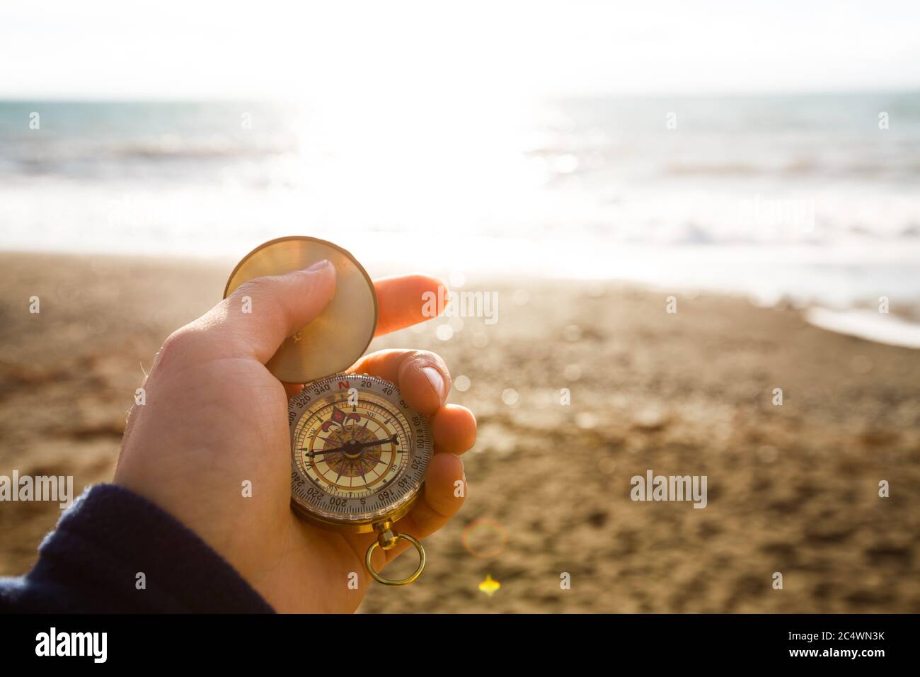 Point of view photo of man holding compass in the hand on the sea and ...