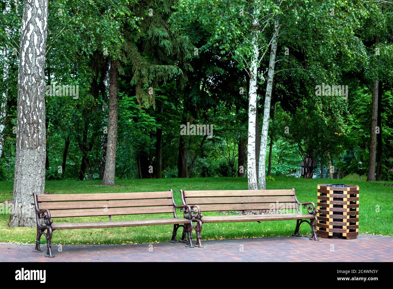 benches with iron forged legs and wooden seats with a wooden litter bin ...