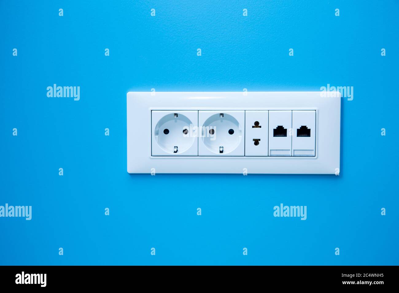 a socket on a light blue wall, a multiple outlet with an internet ...