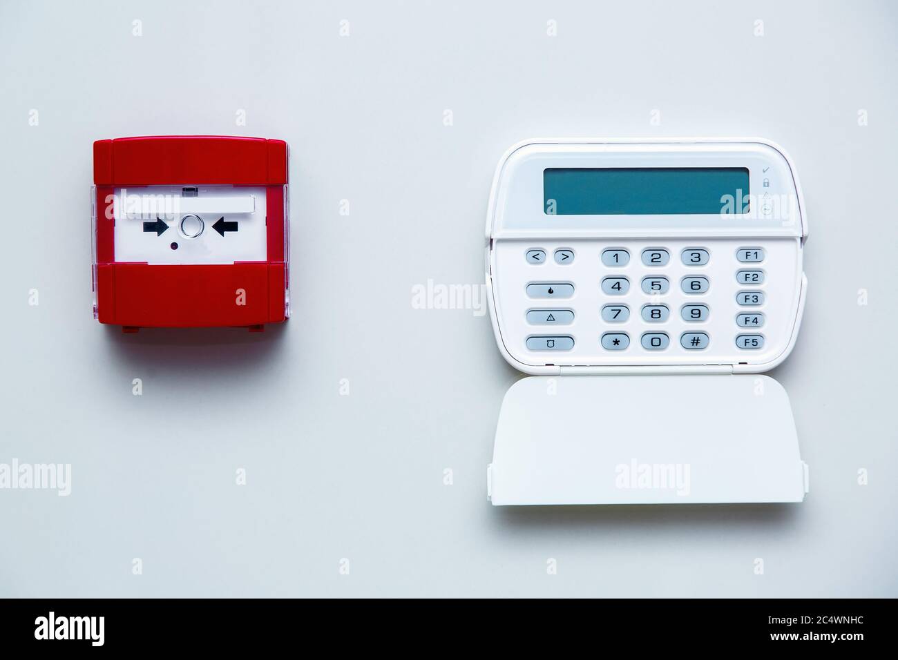 Fire safety button in a red box on a gray wall near a white alarm ...