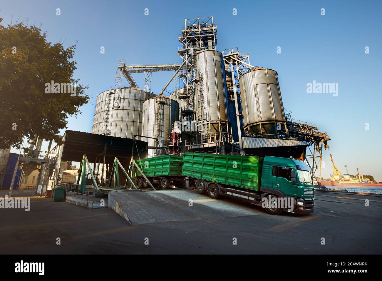 Unloading grain truck at elevator on elevating hydraulic platform ...