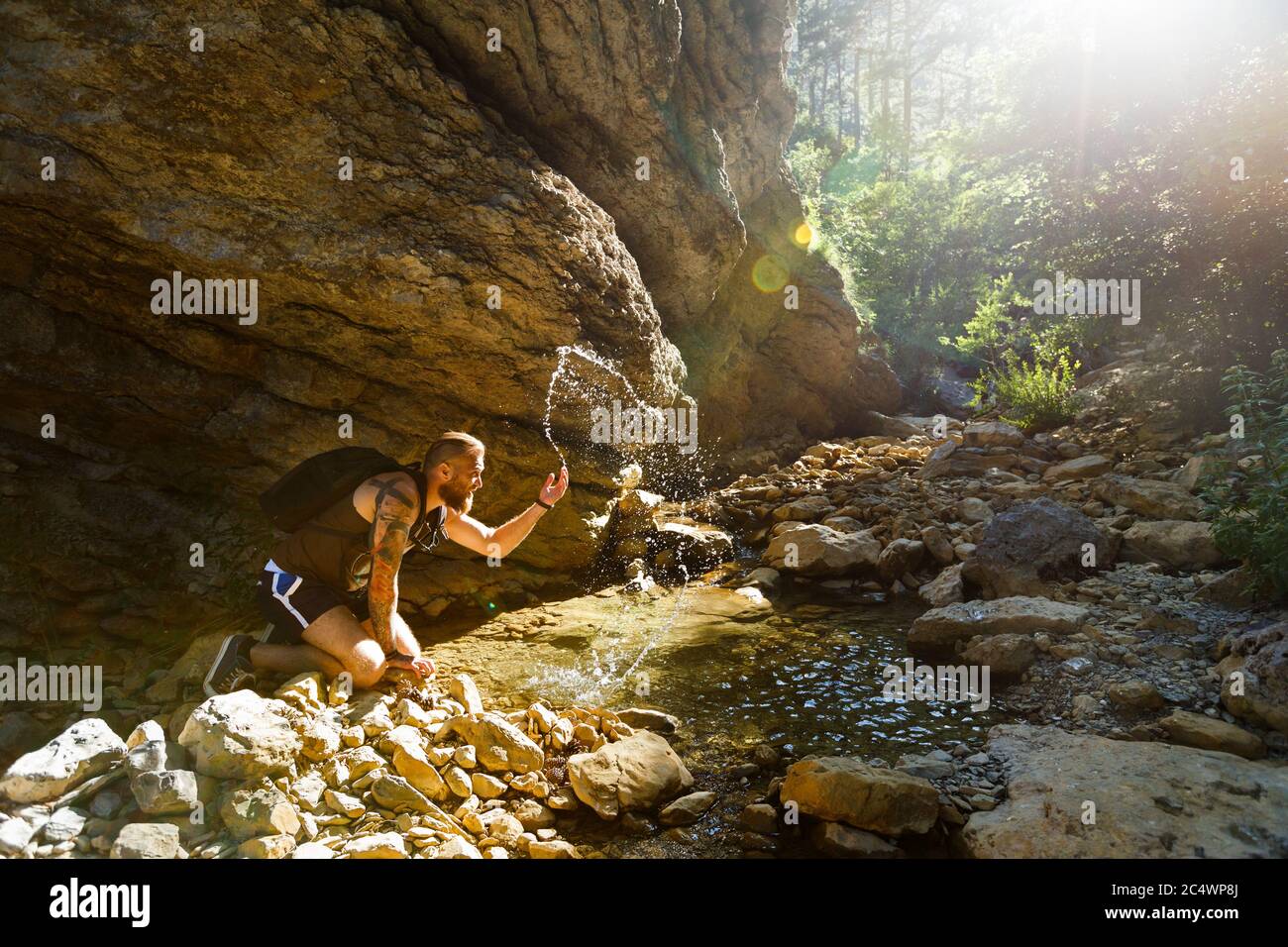 Hiker drinking water from the river. Man enjoys clean fresh unpolluted ...