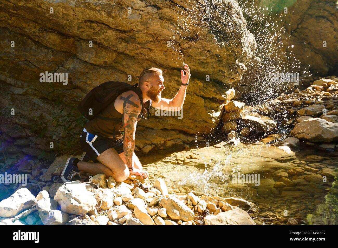 Hiker drinking water from the river. Man enjoys clean fresh unpolluted ...