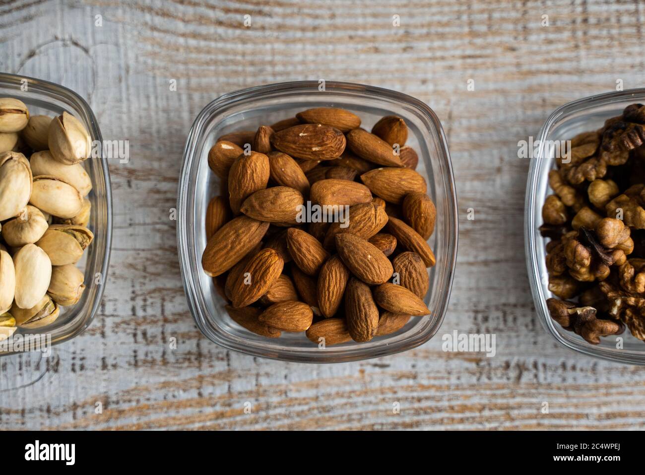 Almond, pistachio and walnut in a small plates which standing on a ...