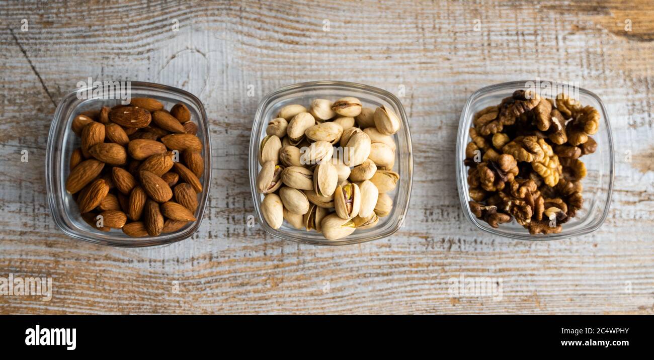 Almond, pistachio and walnut in a small plates which standing on a ...