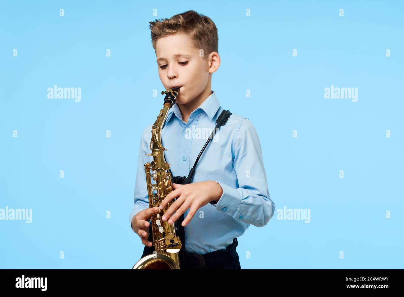 A boy plays a musical instrument saxophone Stock Photo - Alamy