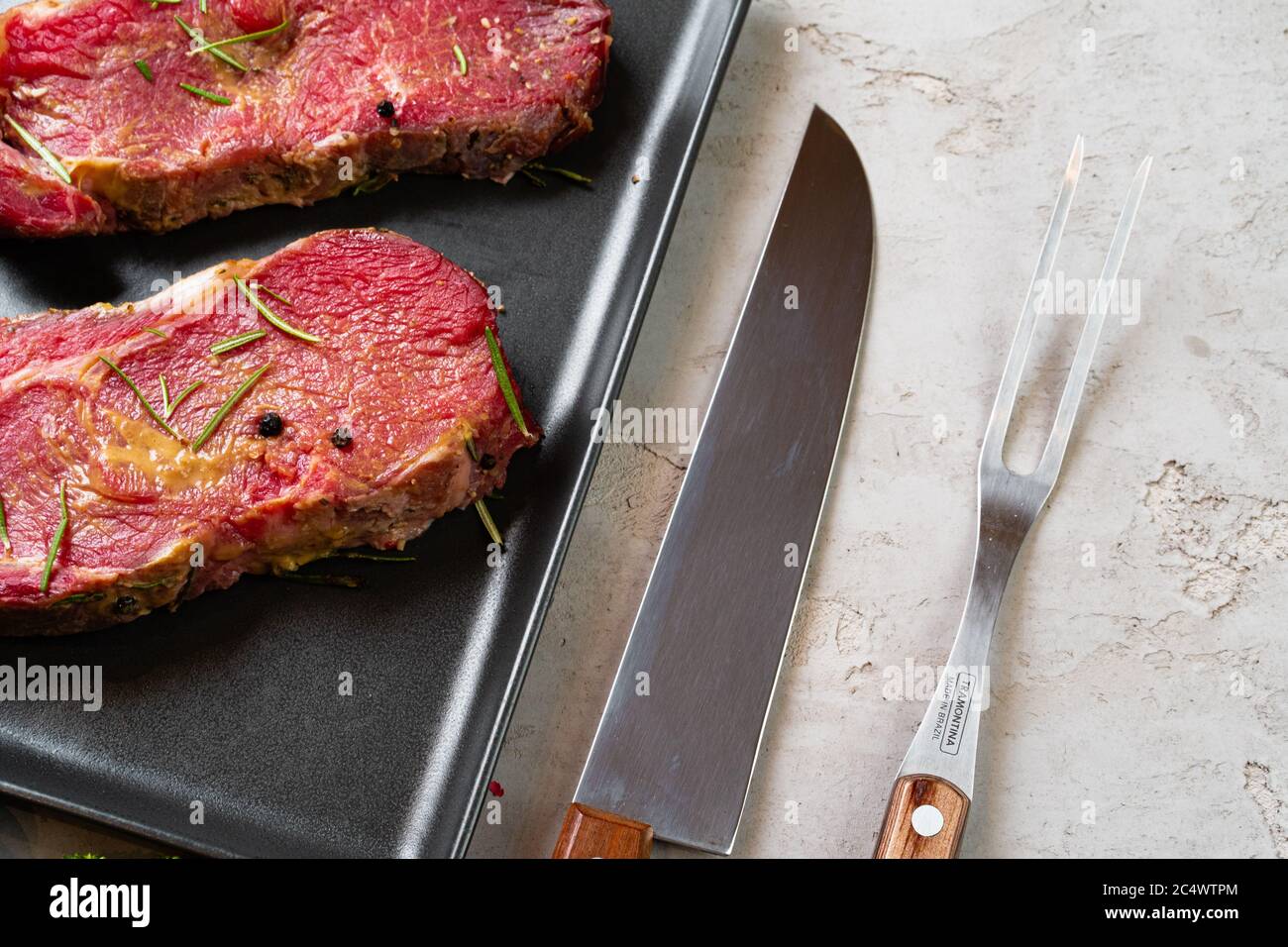 Marinated raw steaks on stone table with spices Stock Photo - Alamy