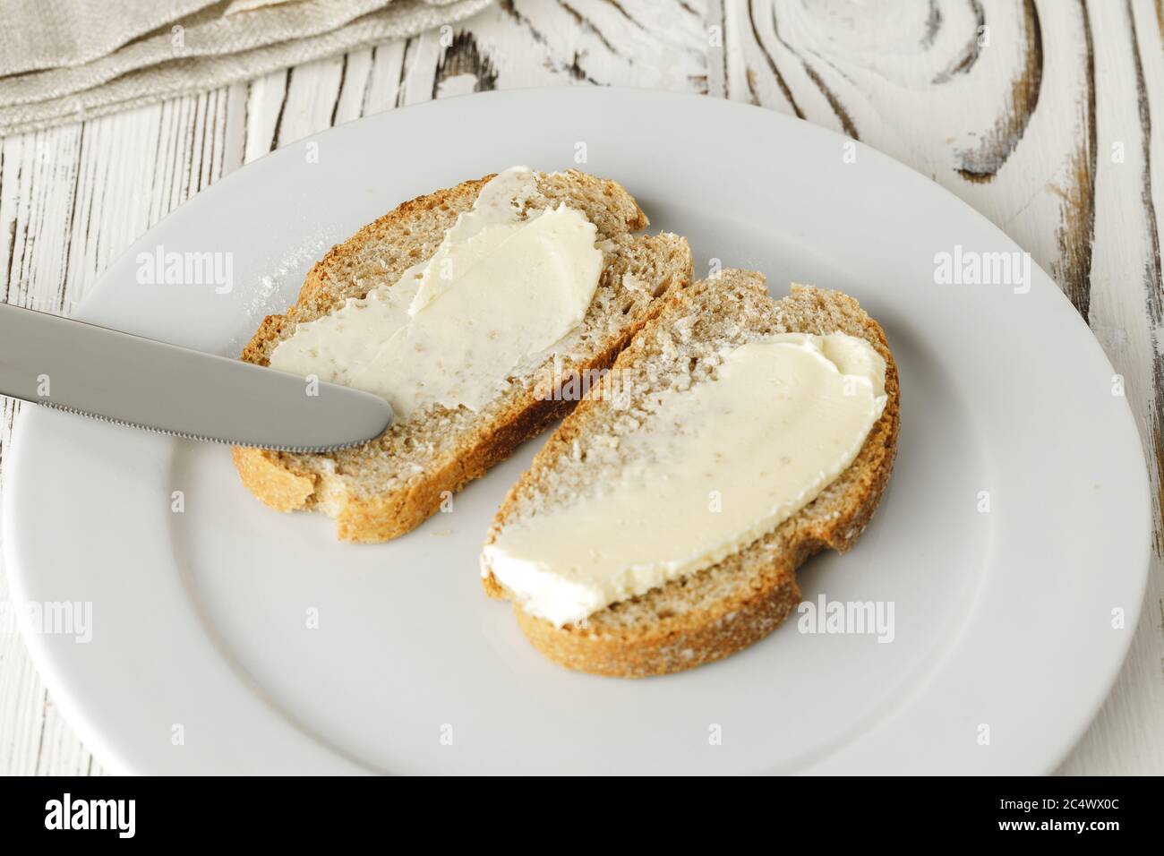Simple breakfast. Toasted bread covered with butter Stock Photo - Alamy