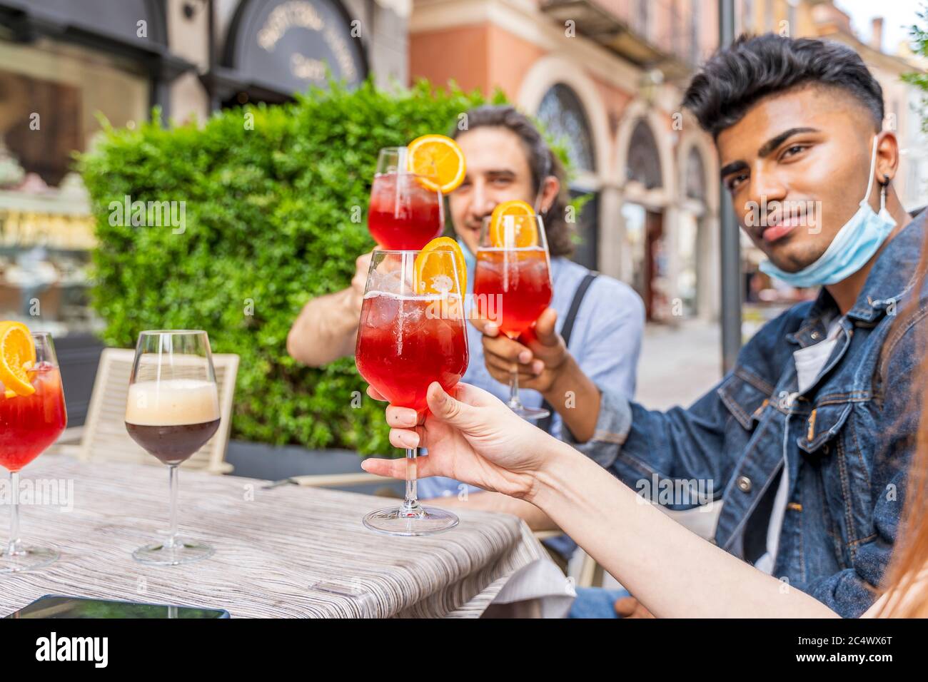 Friends drinking colored cocktail at outdoor bar with face masks - New ...