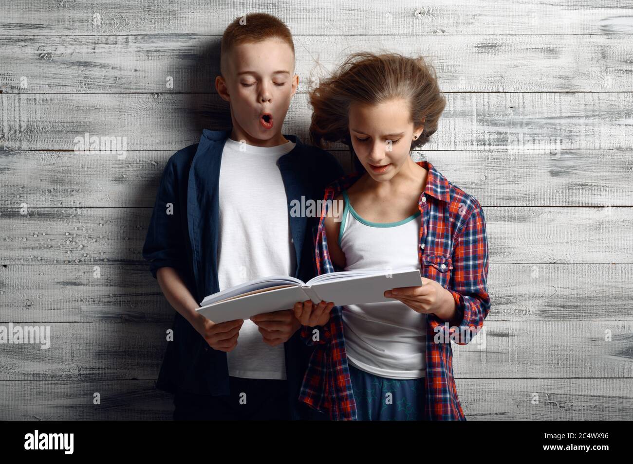 Little boy and girl reding a book against airflow Stock Photo - Alamy