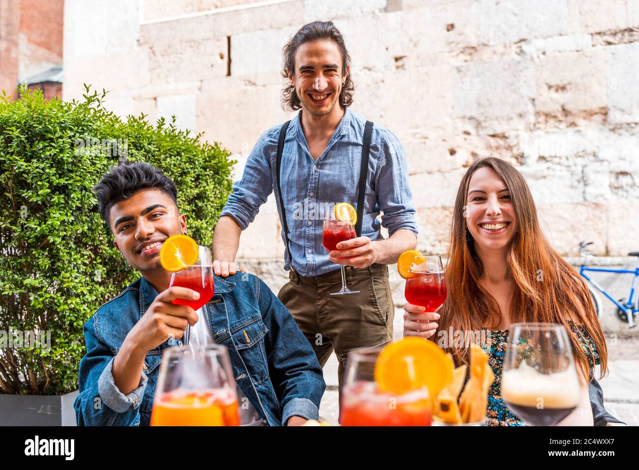 Friends drinking colored cocktail at outdoor bar - New normal ...